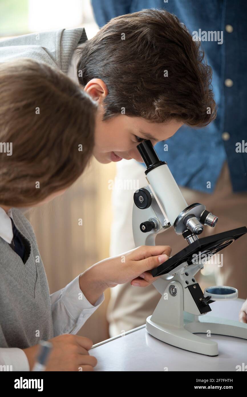 Students using microscope in classroom Stock Photo - Alamy