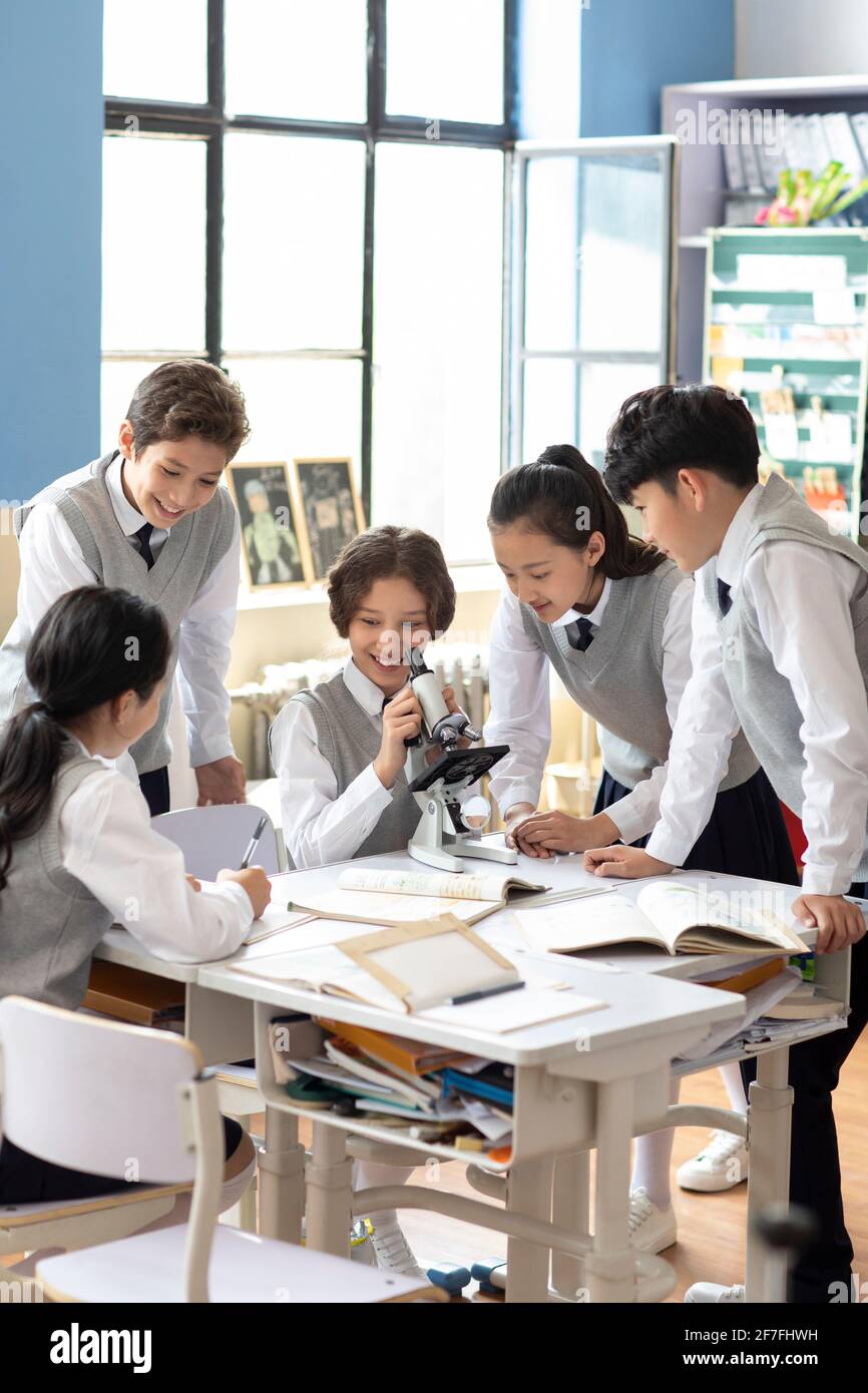 Students using microscope in classroom Stock Photo - Alamy