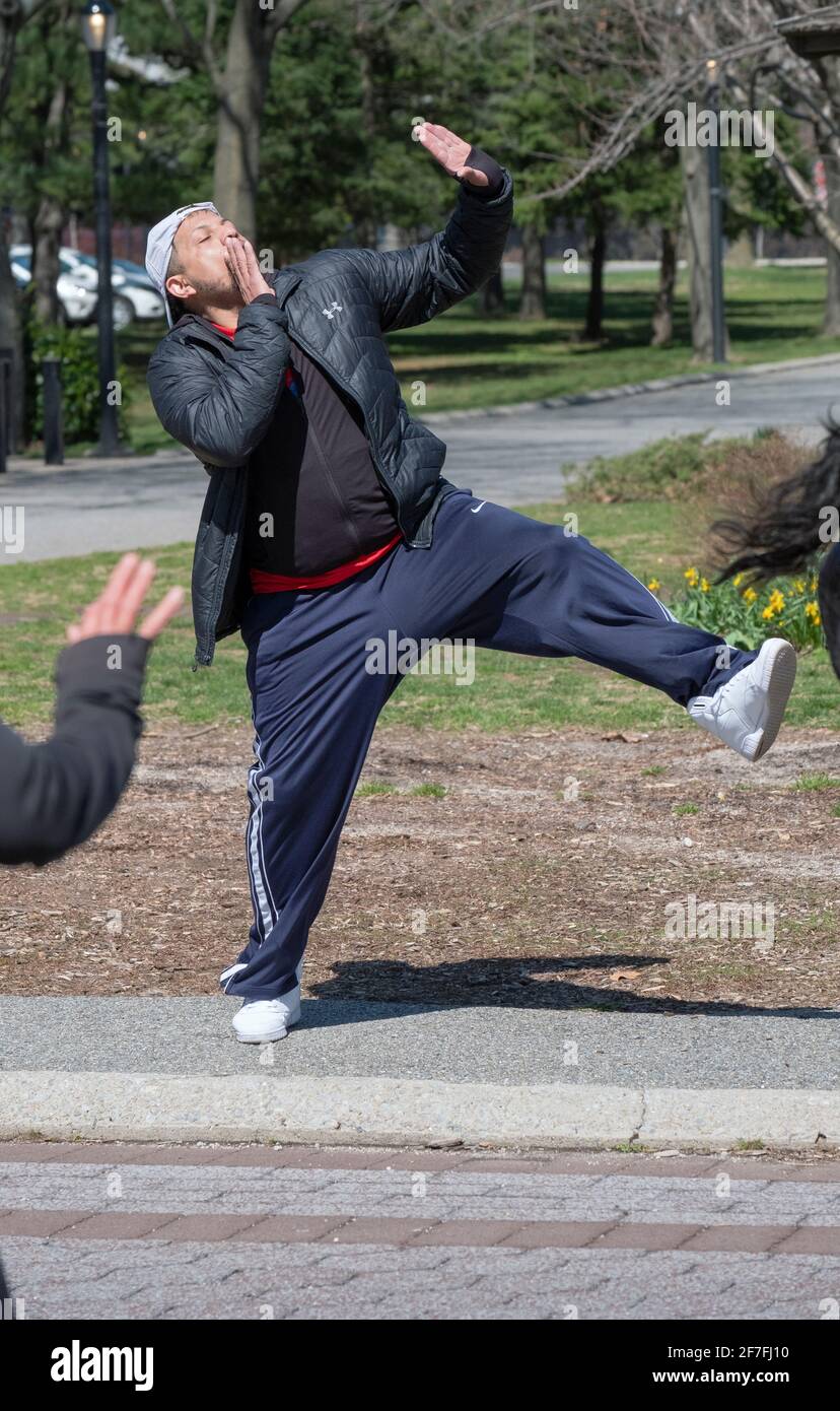 A man leads a Zumba class through a vigorous dance exercise workout at ...