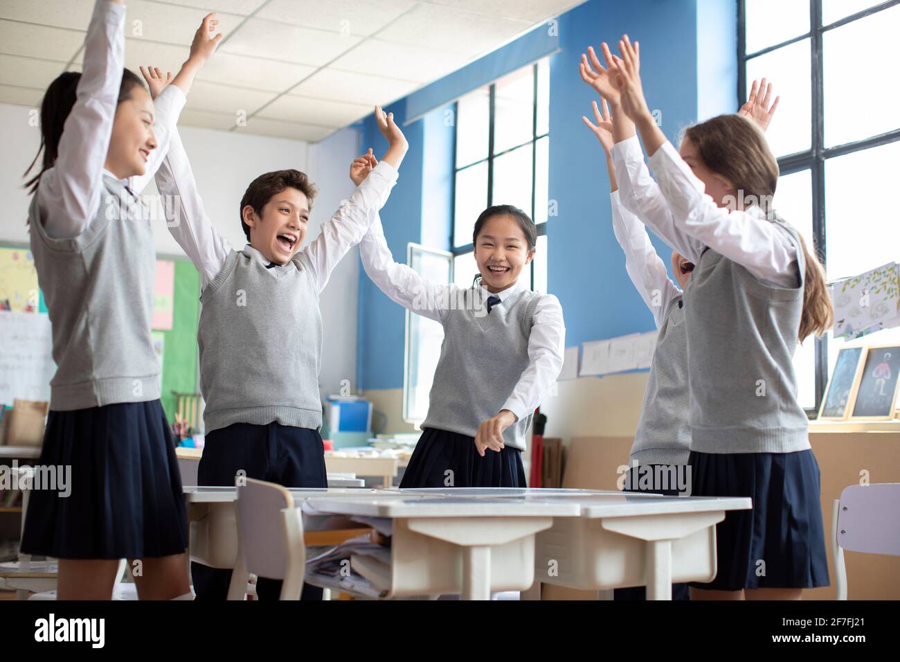 Classmates cheering in classroom Stock Photo - Alamy