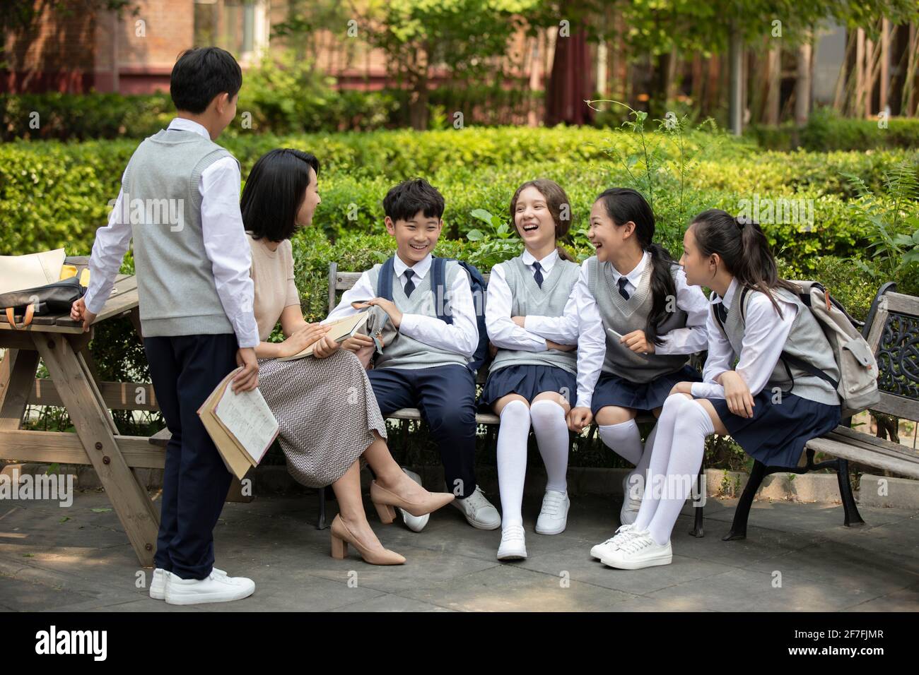 Teacher talking with students on campus Stock Photo - Alamy