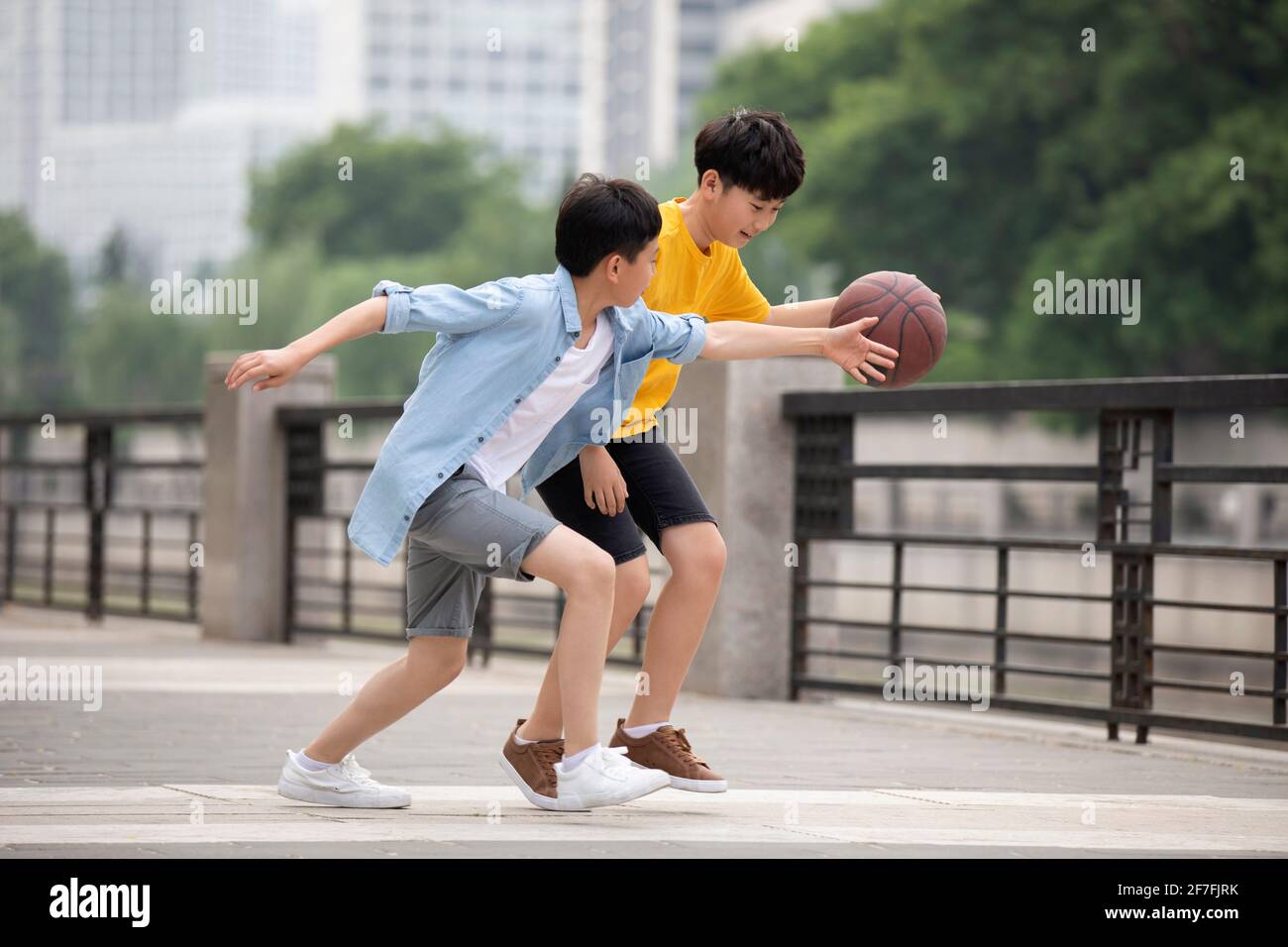 Boys playing basketball outdoors Stock Photo - Alamy