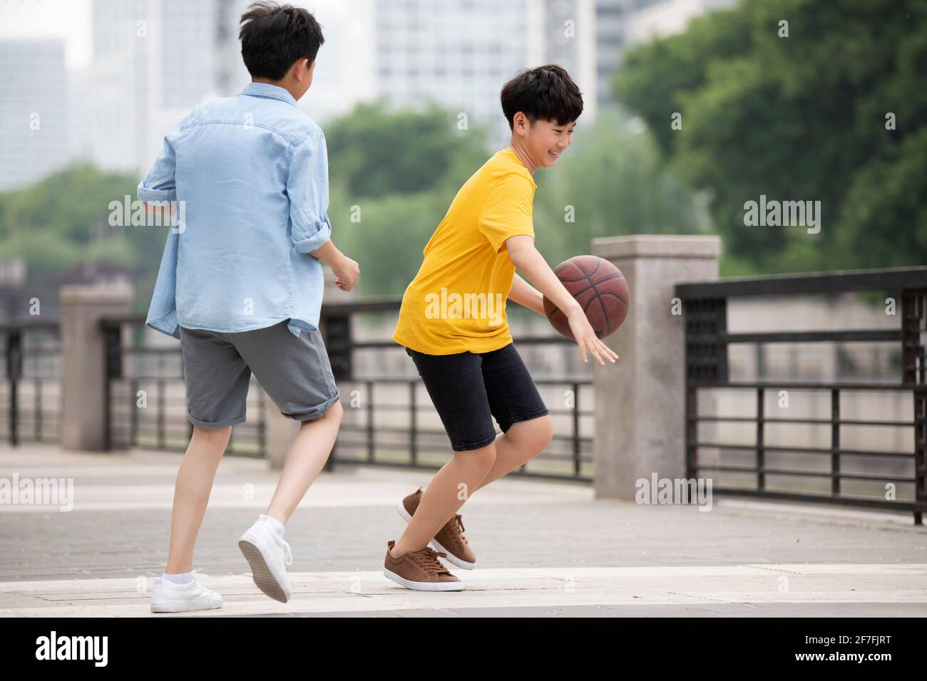 Boys playing basketball outdoors Stock Photo - Alamy