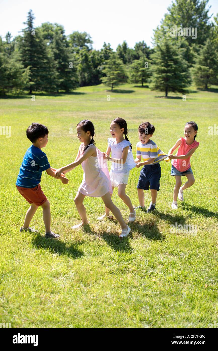 Happy children playing games on meadow Stock Photo - Alamy