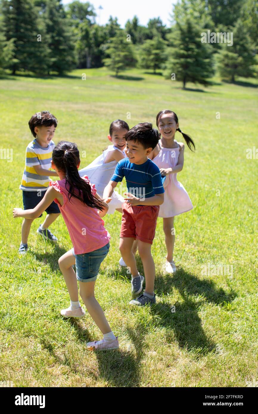 Happy children playing games on meadow Stock Photo - Alamy