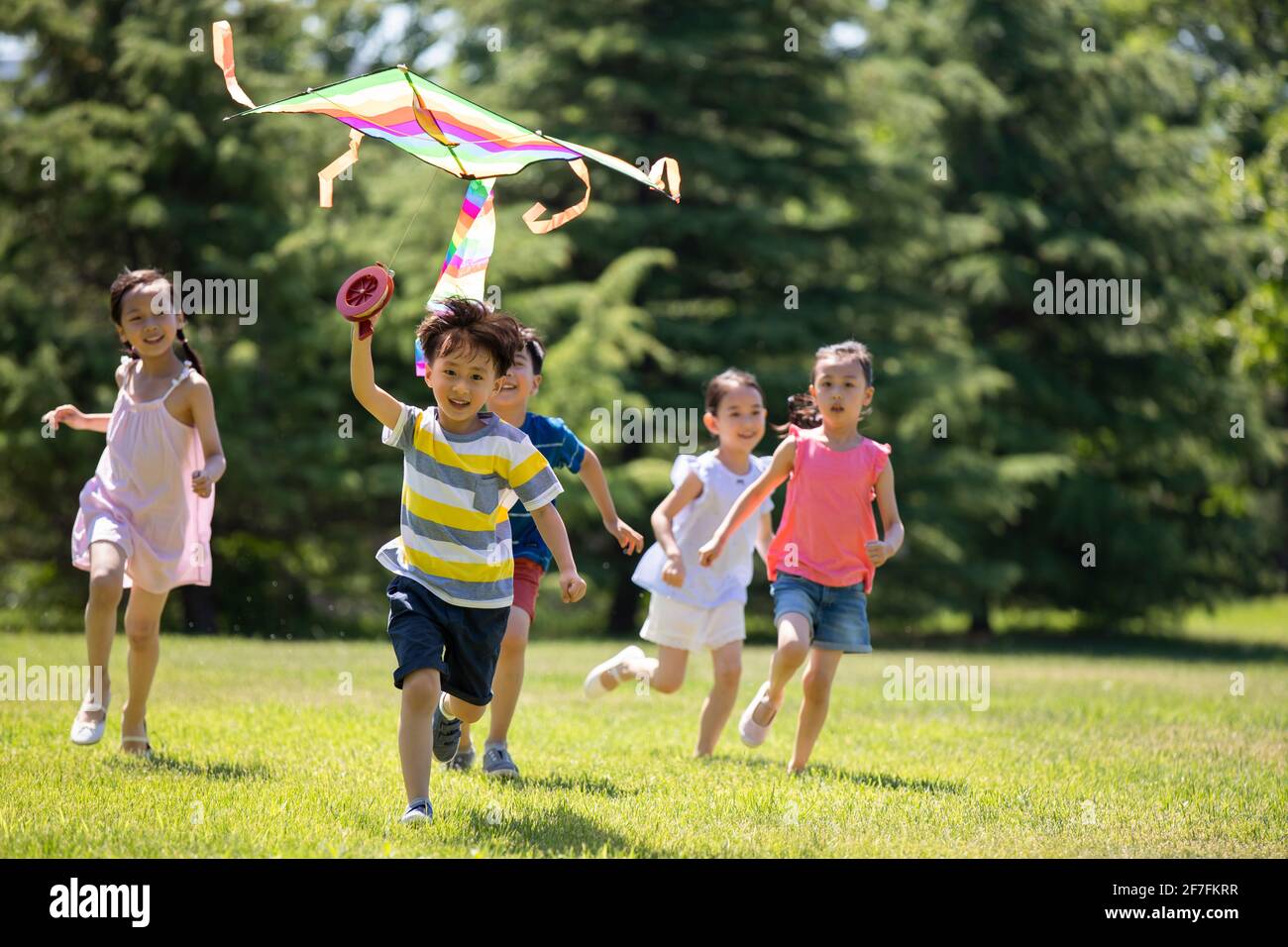Happy children running with a kite on meadow Stock Photo - Alamy