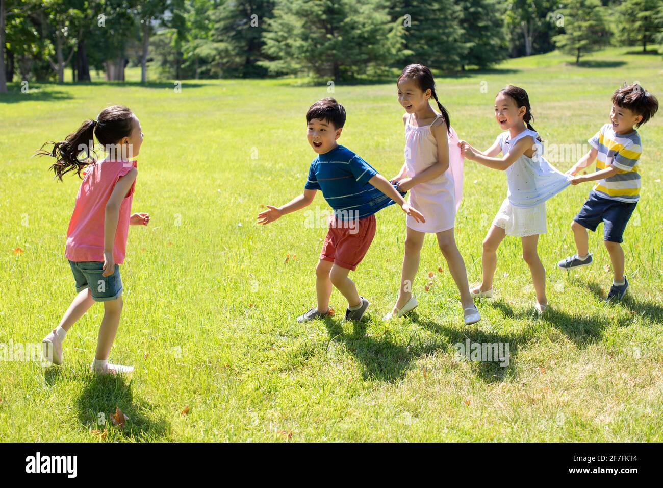 Happy children playing games on meadow Stock Photo - Alamy