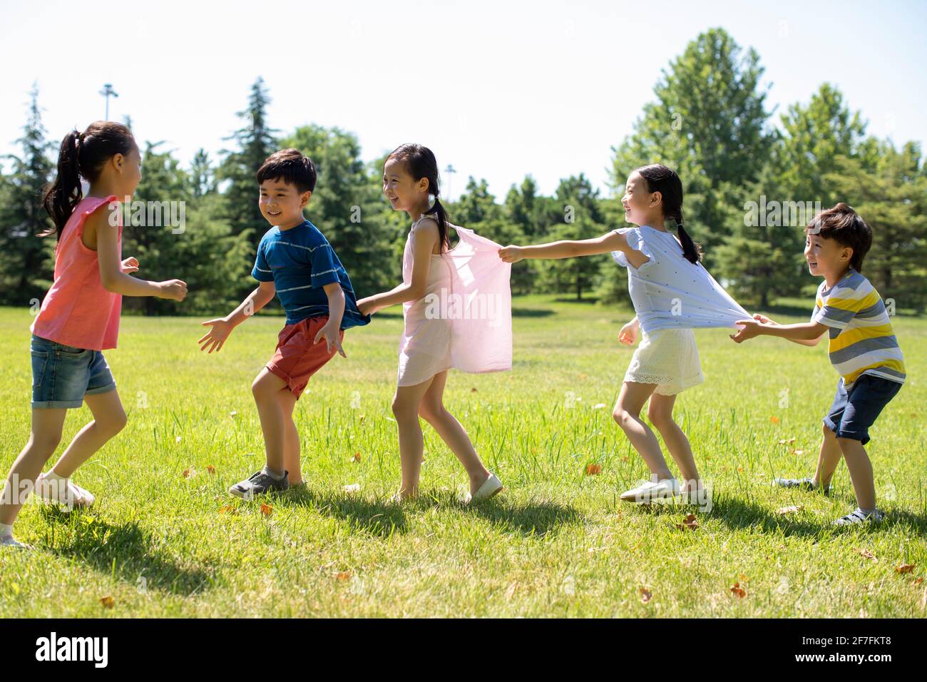 Happy children playing games on meadow Stock Photo - Alamy