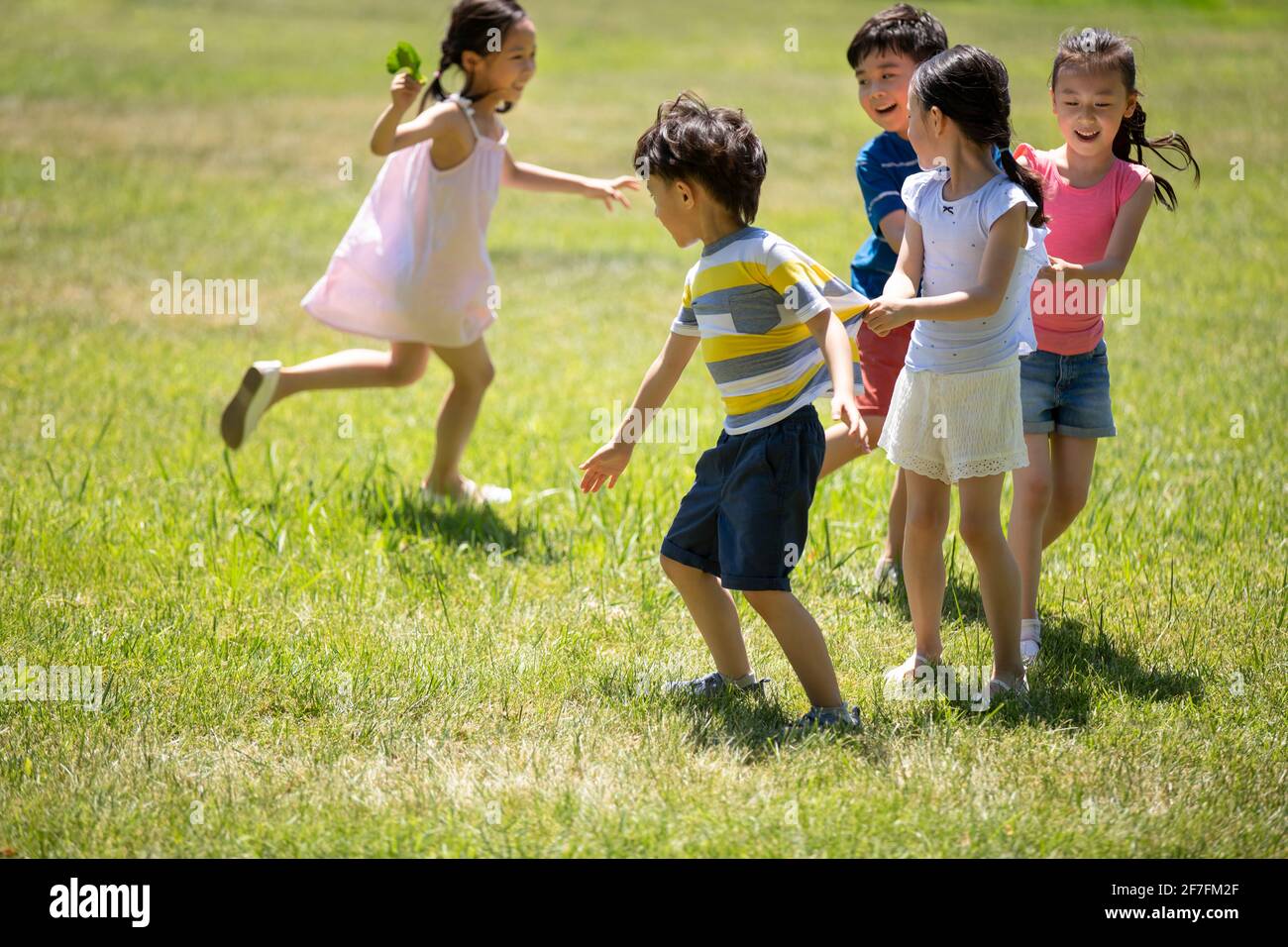 Happy children playing games on meadow Stock Photo - Alamy