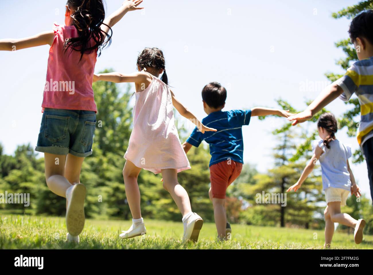 Happy children playing on meadow Stock Photo - Alamy