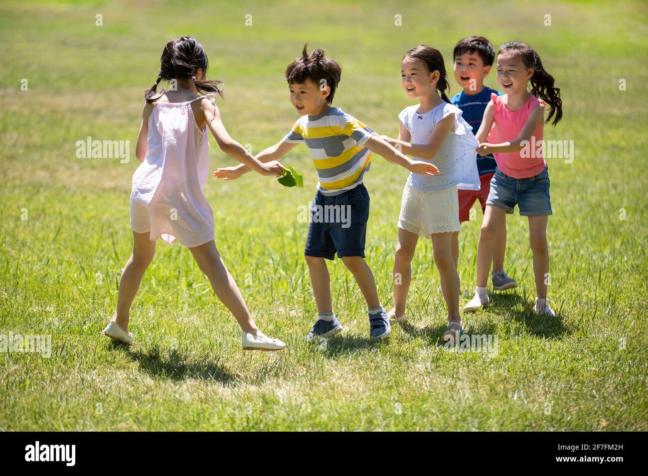 Happy children playing games on meadow Stock Photo - Alamy