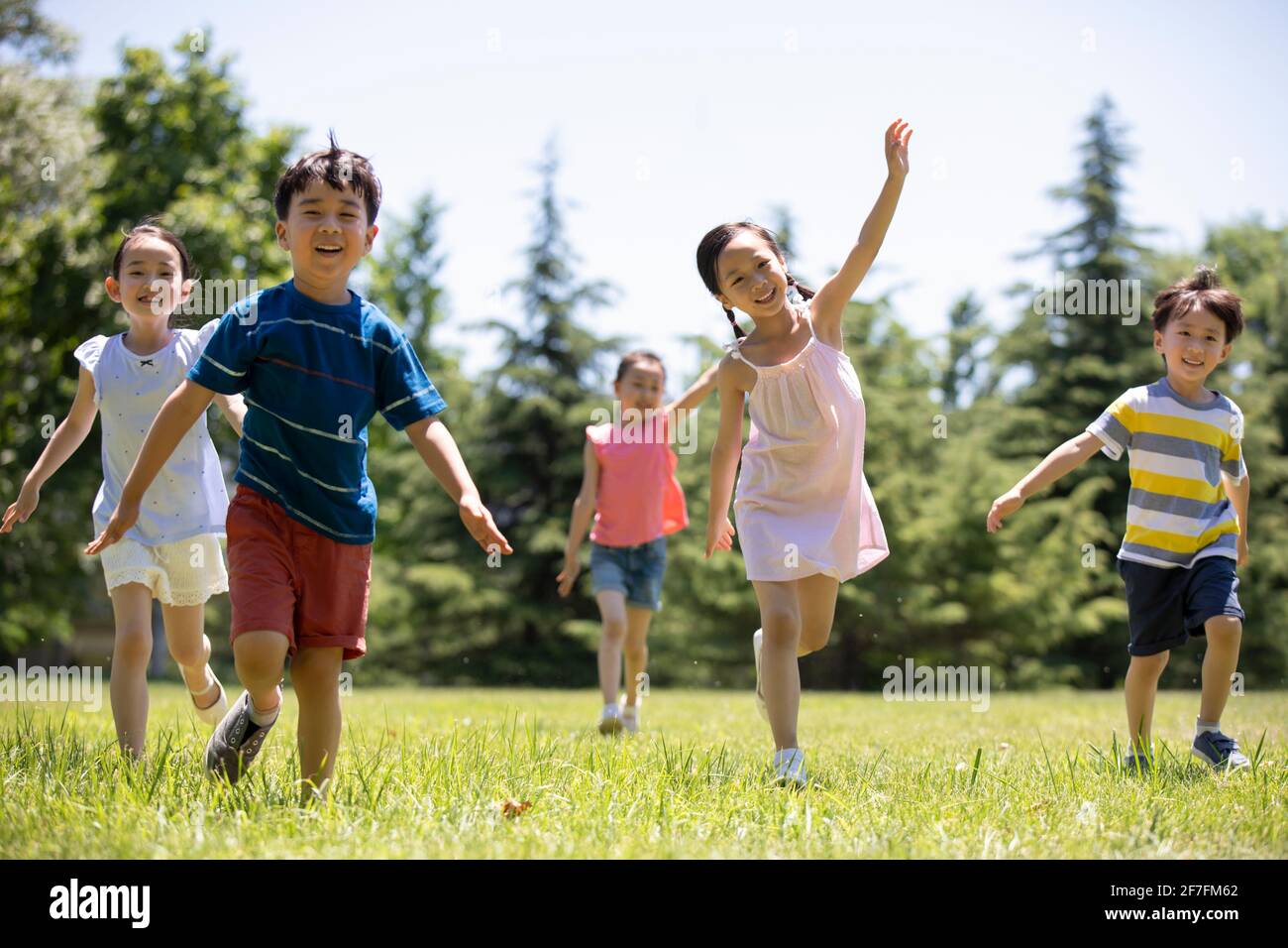 Happy children playing on meadow Stock Photo - Alamy