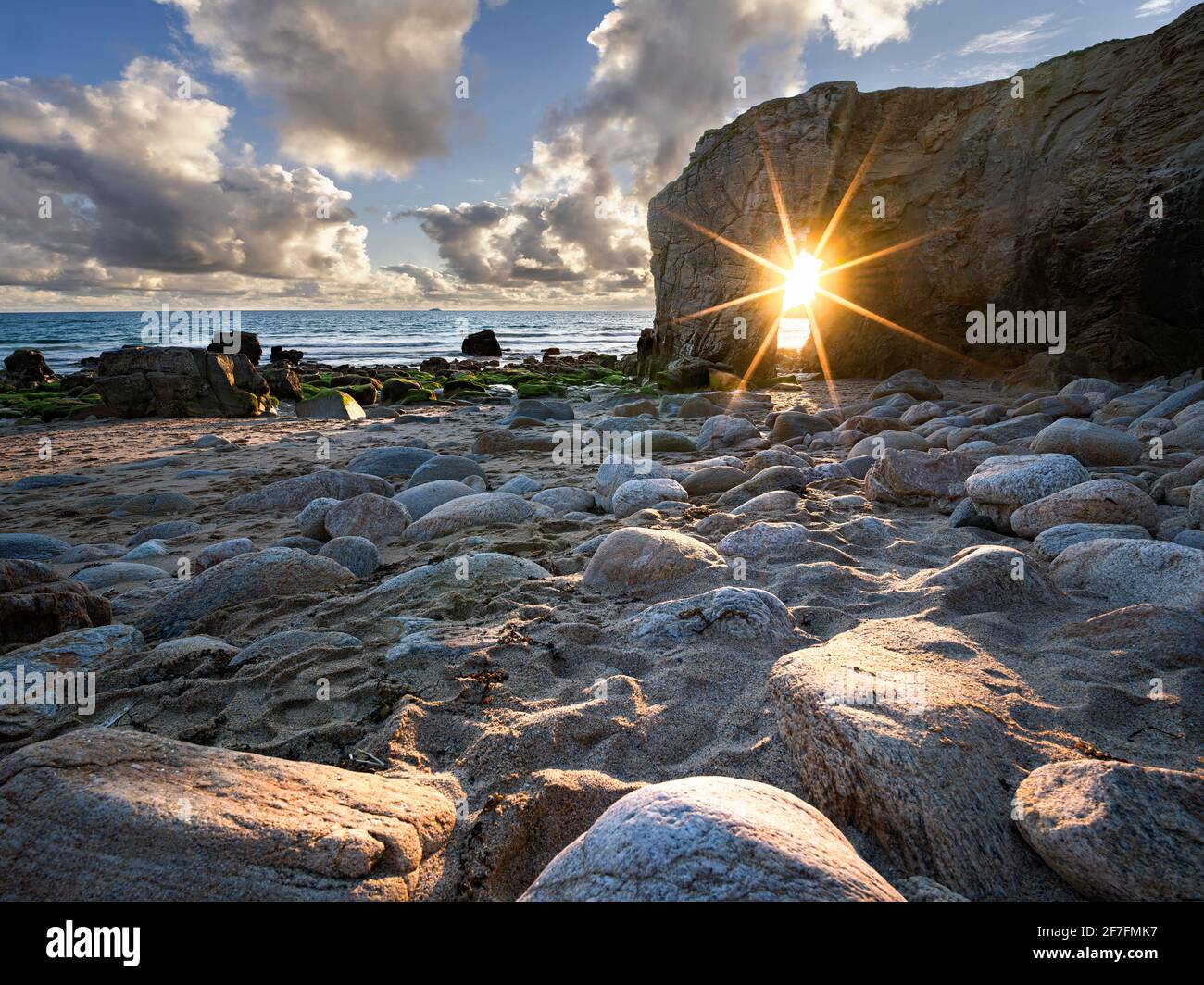 Sun burst aligned with the natural arch of Port Blanc, Quiberon ...