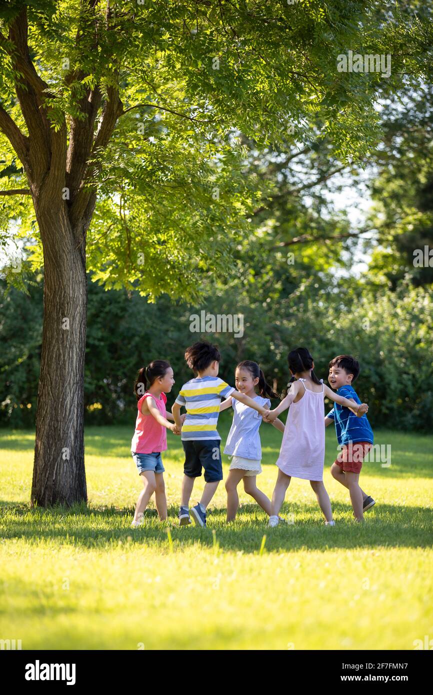 Happy children playing on meadow Stock Photo - Alamy