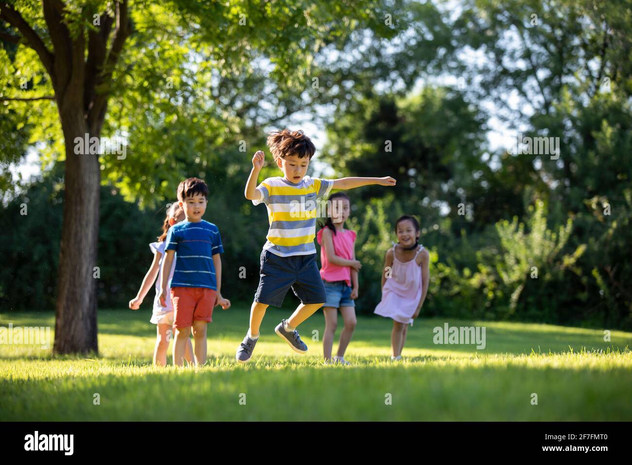 Happy children playing on meadow Stock Photo - Alamy