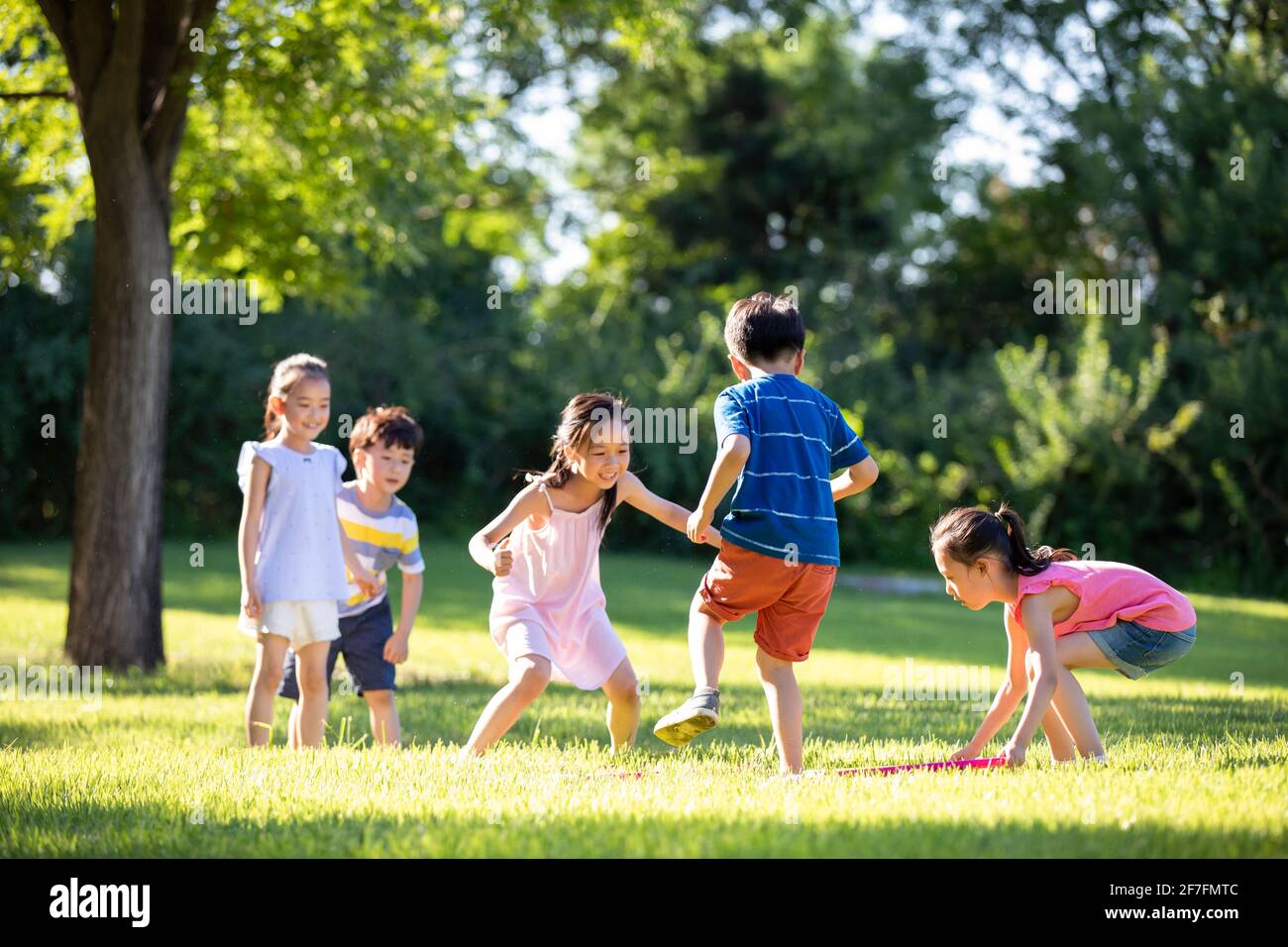 Happy children playing on meadow Stock Photo - Alamy