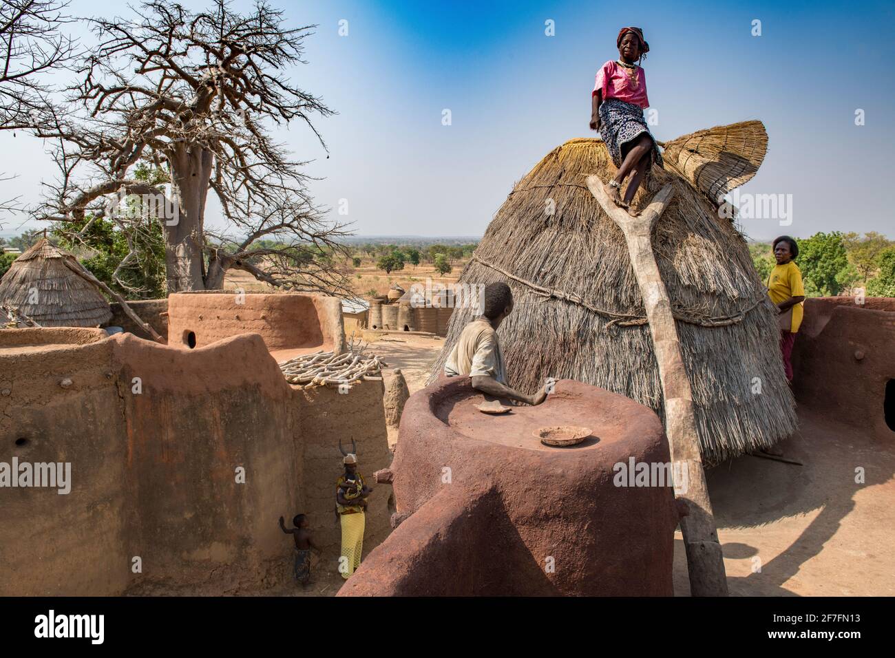 Old Batammariba woman standing in the granary on top of her takienta ...