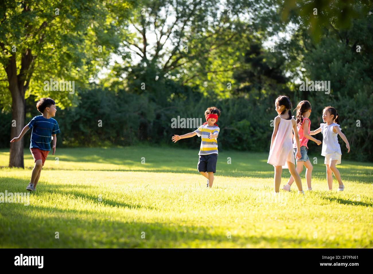 Happy children playing hide and seek on meadow Stock Photo - Alamy
