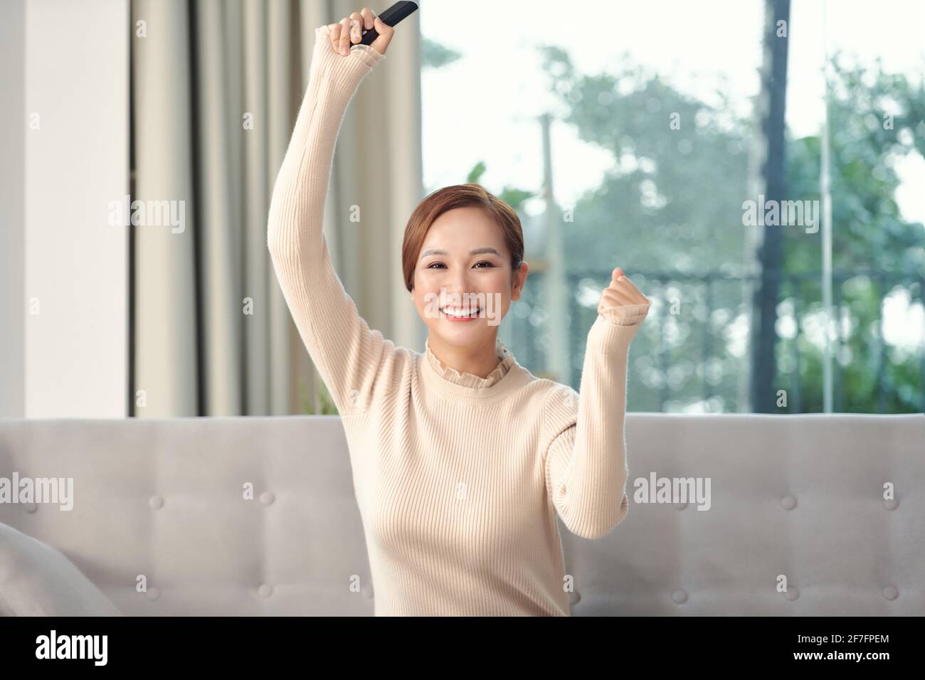 Ecstatic positive girl student sit divan legs barefoot crossed hold ...