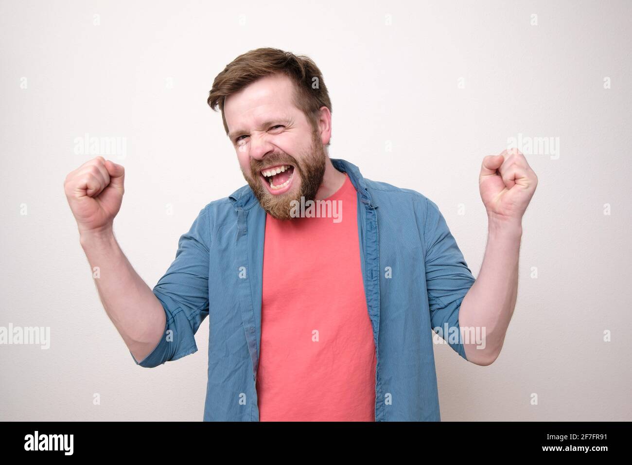 Joyful man makes a winner gesture, he is happy and emotionally shouts ...