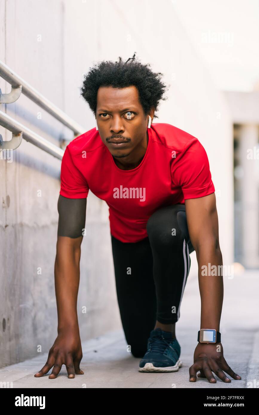 Athlete man in start position preparing to run outdoors Stock Photo - Alamy