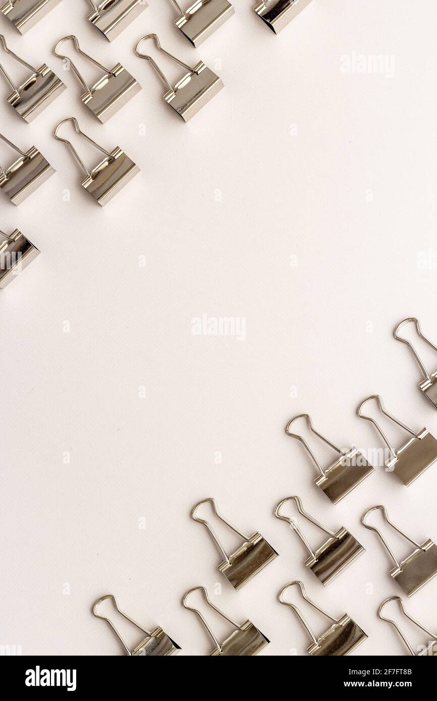 Frame of silver paper binder clips top view. Office supplies pattern ...
