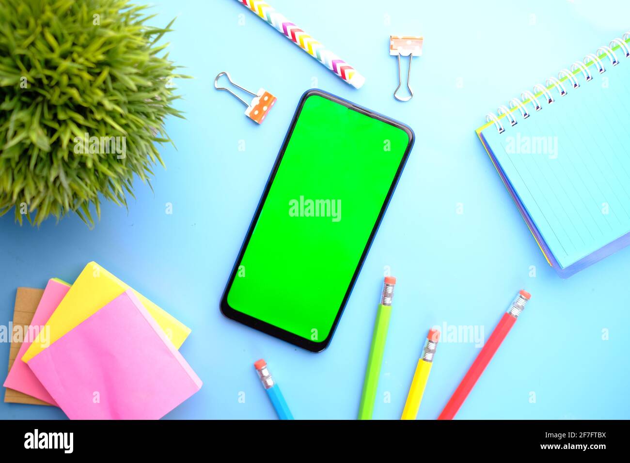 top view of man hand using smart phone with stationary on blue ...