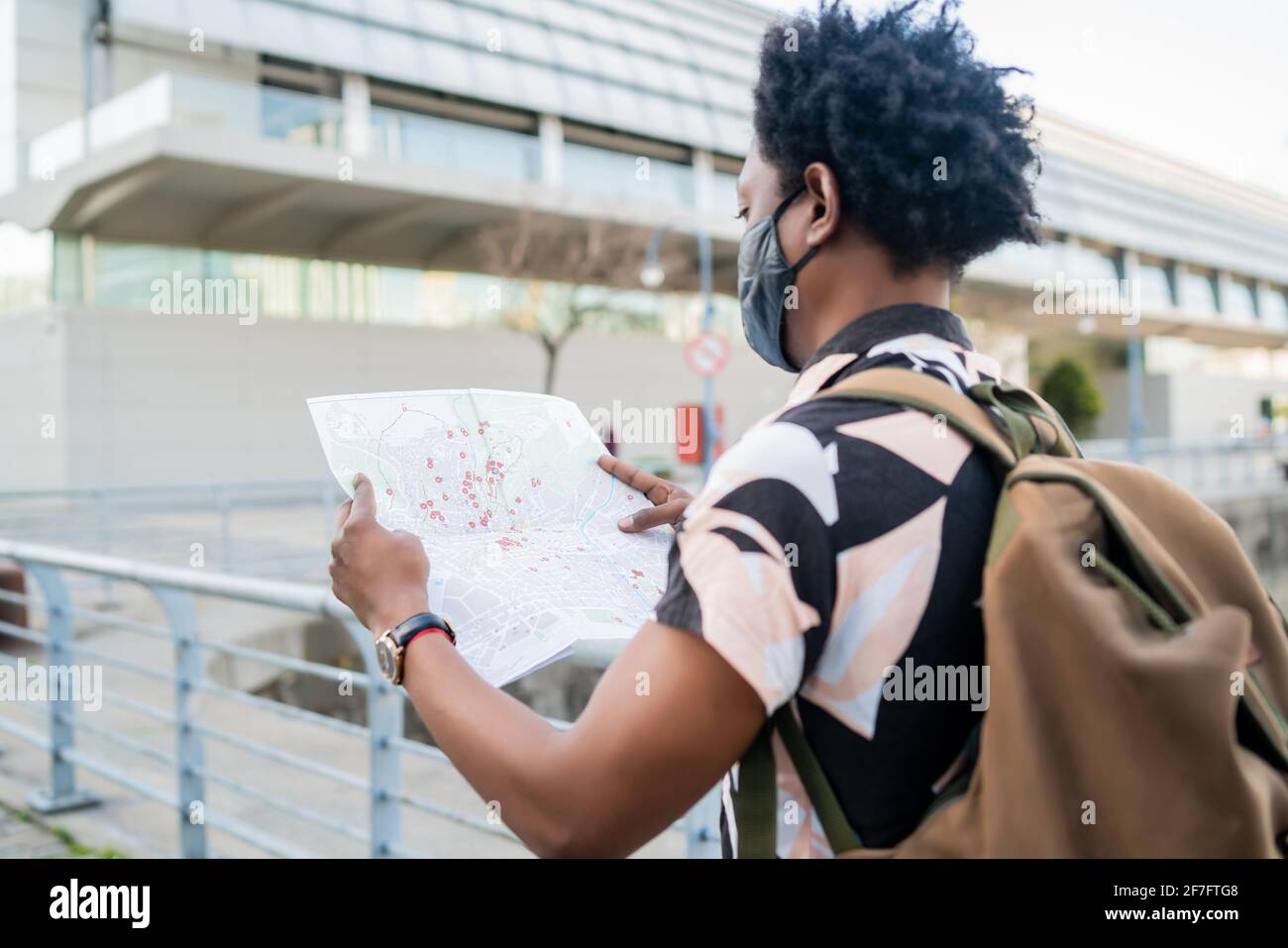 Tourist man looking for directions on map Stock Photo - Alamy
