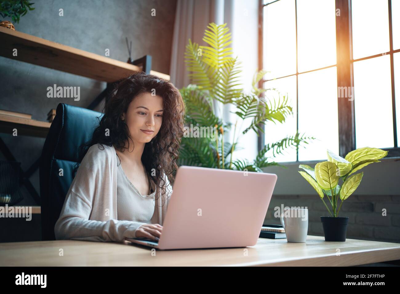cheerful female manager working with laptop and typing at home office Stock Photo - Alamy
