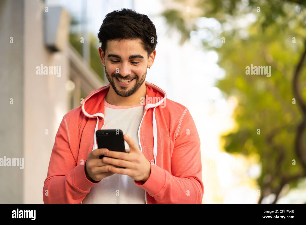 Young man using his mobile phone outdoors Stock Photo - Alamy