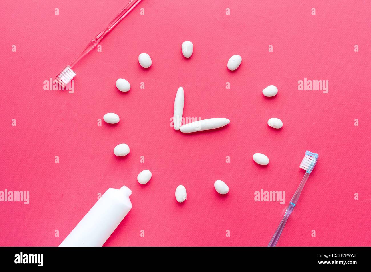 Morning routine concept. Clock made of toothpaste with toothbrushes ...