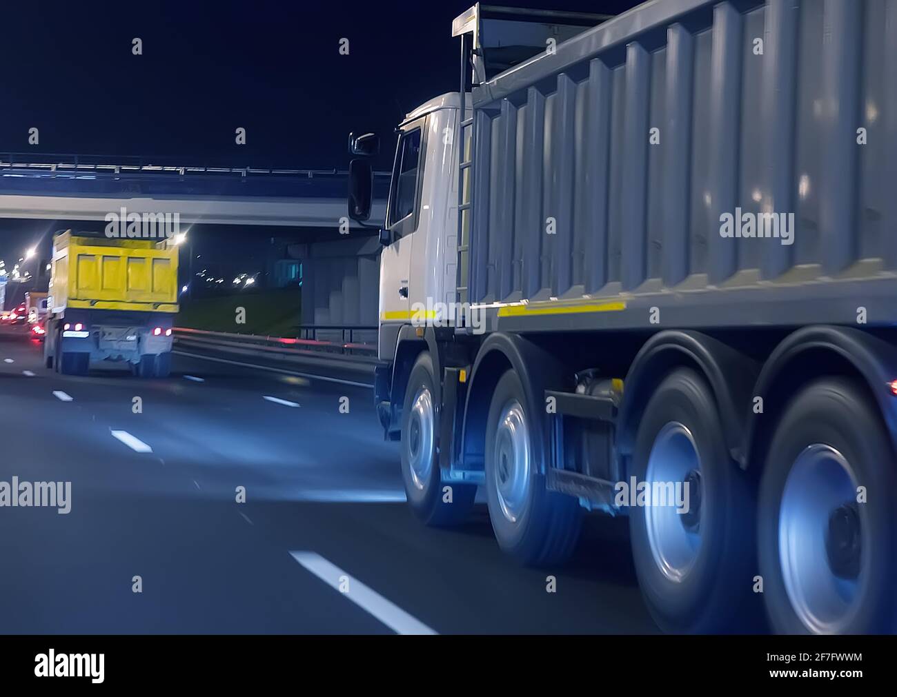 dump trucks transport freight on the night highway Stock Photo - Alamy