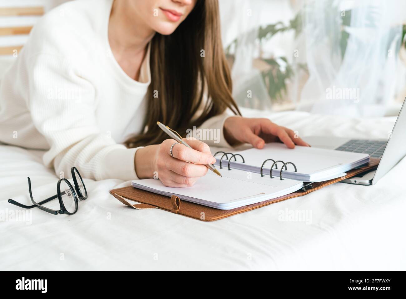 Young woman writes in notepad hi-res stock photography and images - Alamy