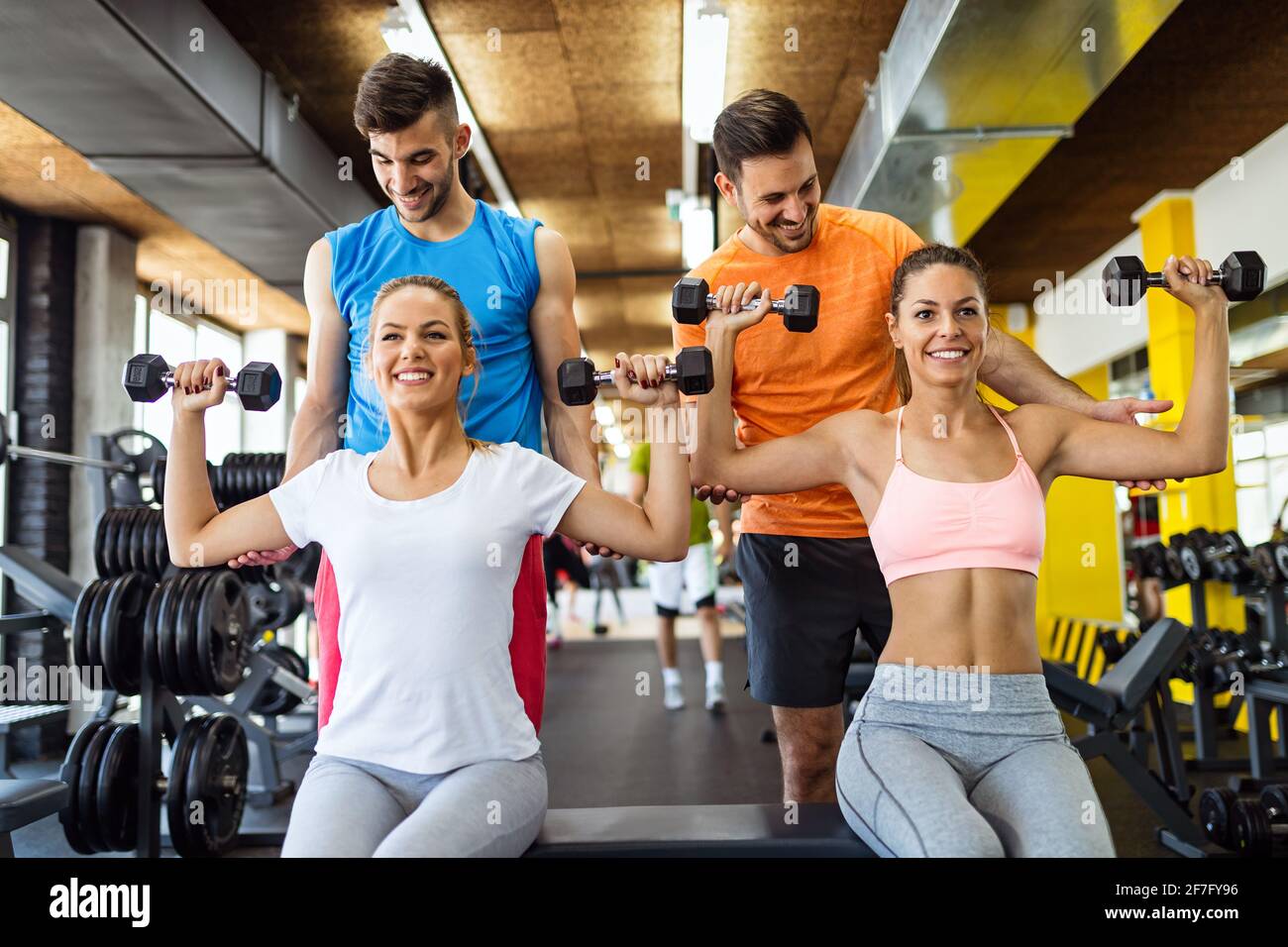Group of young fit people doing exercises in gym to stay healthy Stock ...