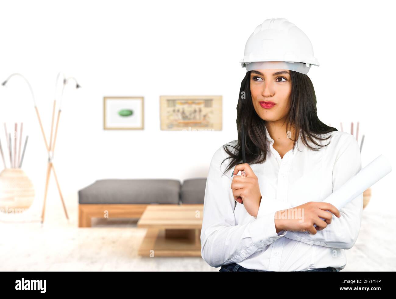 A female architect with protective helmet inside a modern living room ...