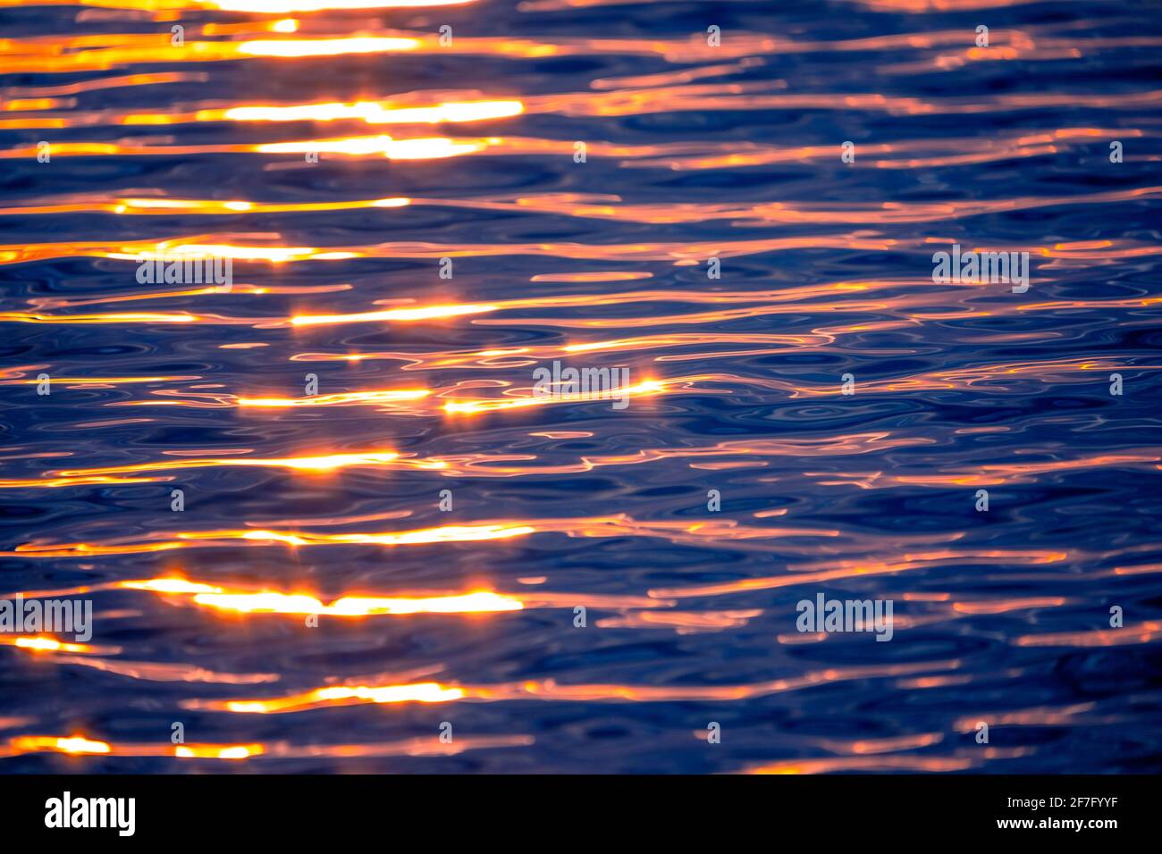 Sea waves texture with sunset or sunrise light shining on the water ...