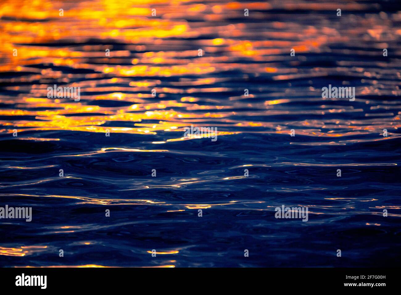 Sea waves texture with sunset or sunrise light reflecting on the water ...