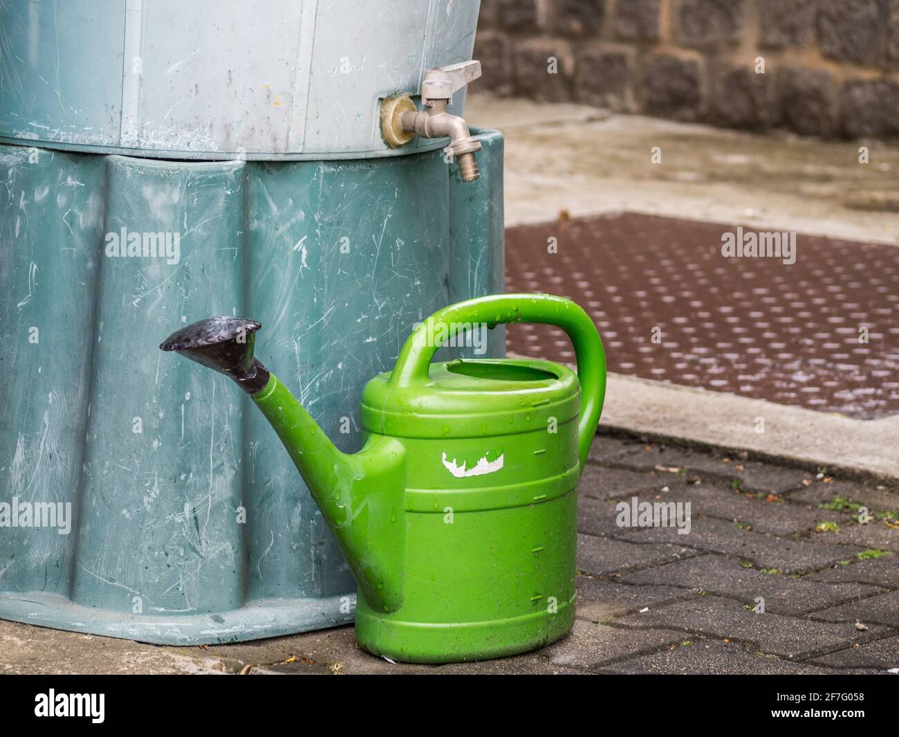 green watering cans in the garden Stock Photo - Alamy