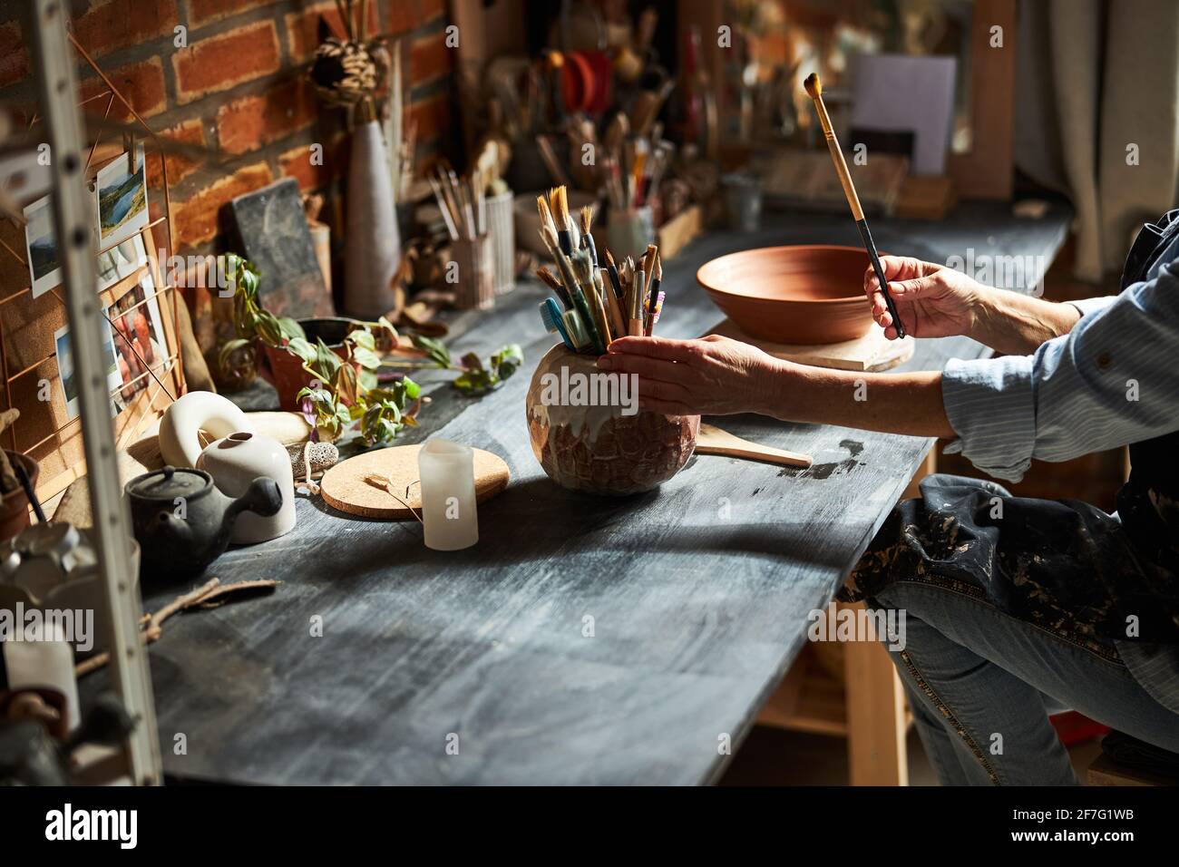 Ceramic artist painting earthenware in pottery workshop Stock Photo - Alamy