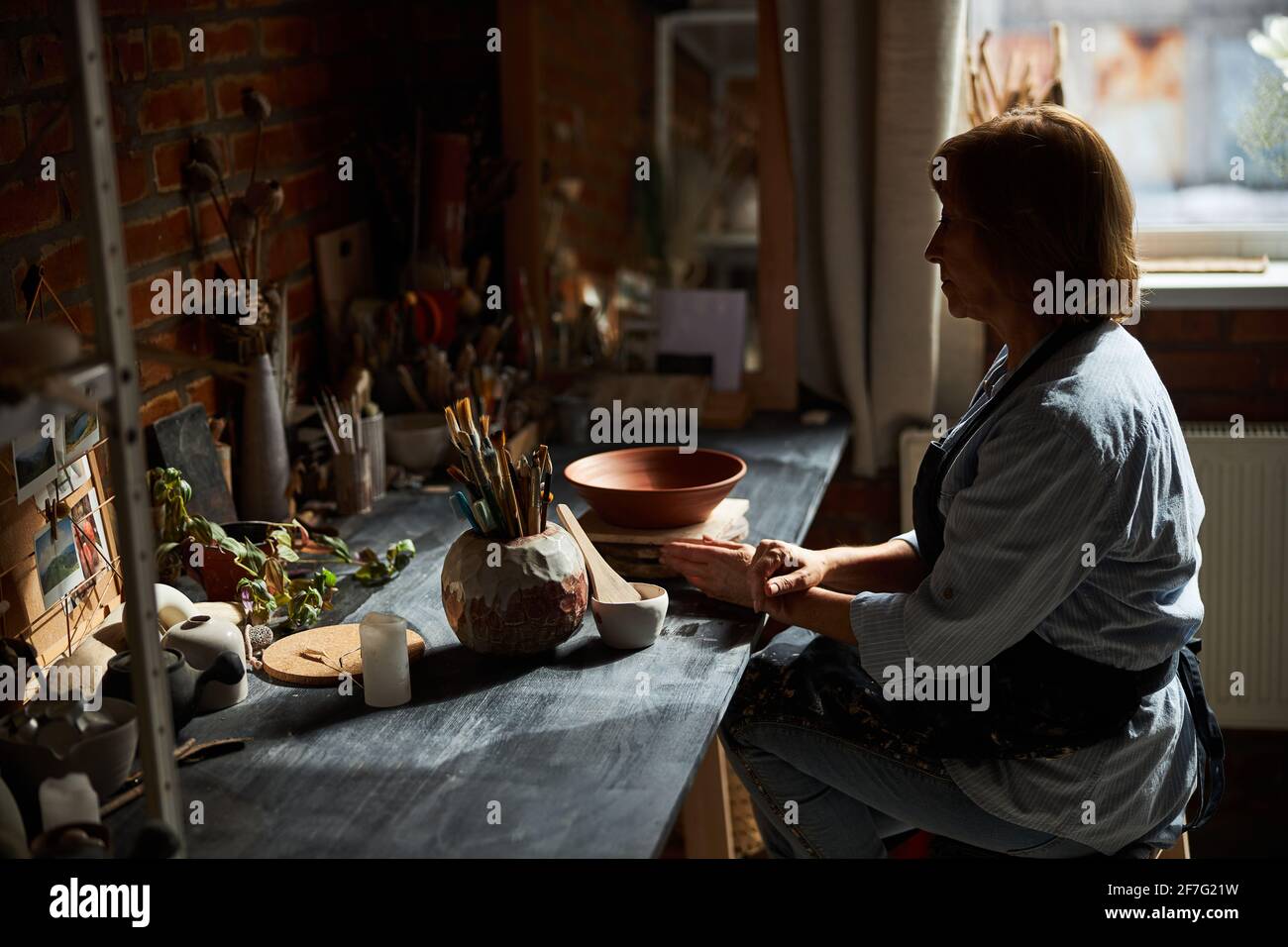 Nice female ceramic artist working in pottery workshop Stock Photo - Alamy