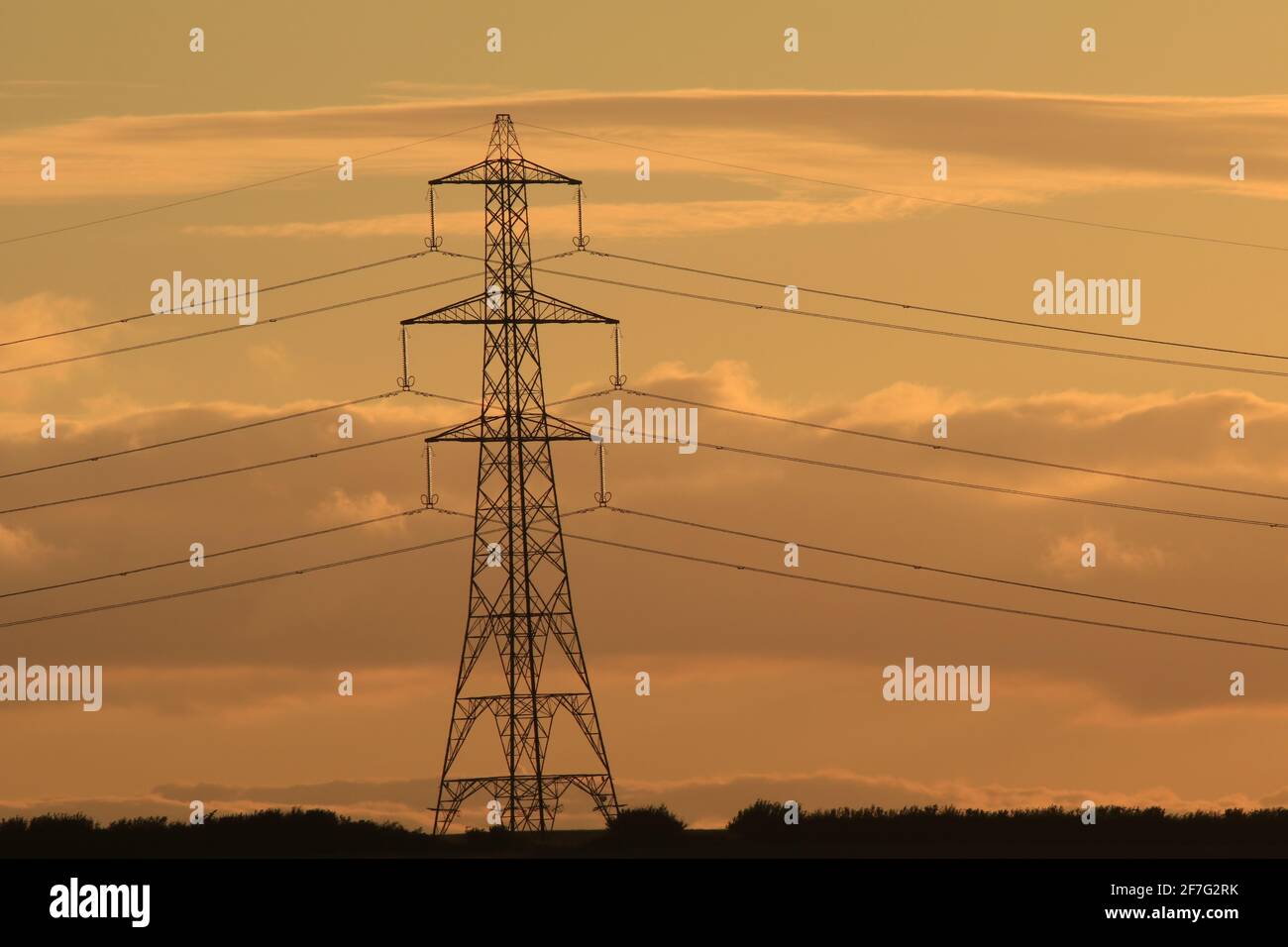Electricity Pilon against a sunset sky and could Stock Photo - Alamy