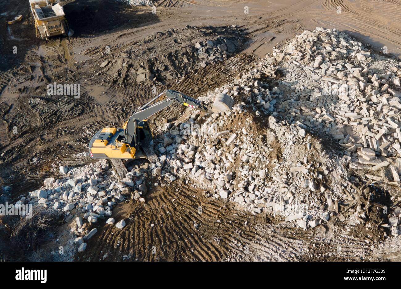 Recycling concrete and construction waste from demolition. Excavator at ...