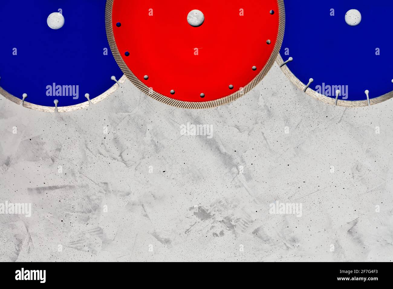 Cutting diamond discs of blue and red color on a gray concrete ...