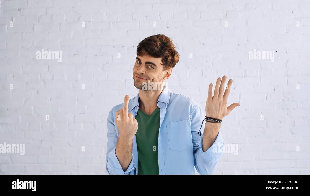 cheerful man showing middle finger and looking at camera Stock Photo ...
