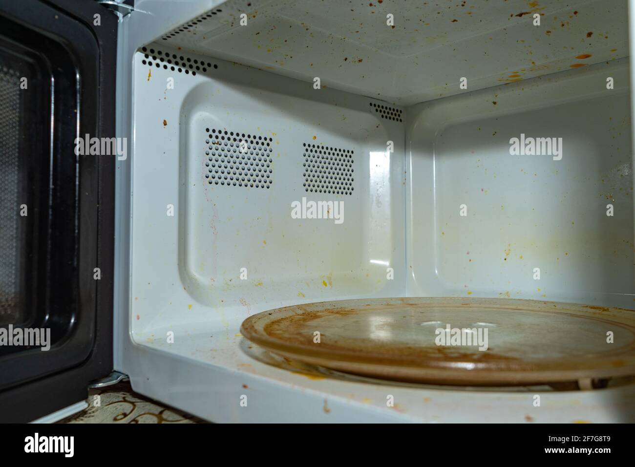 Dirty microwave oven. With burnt paint on the walls and traces of ...
