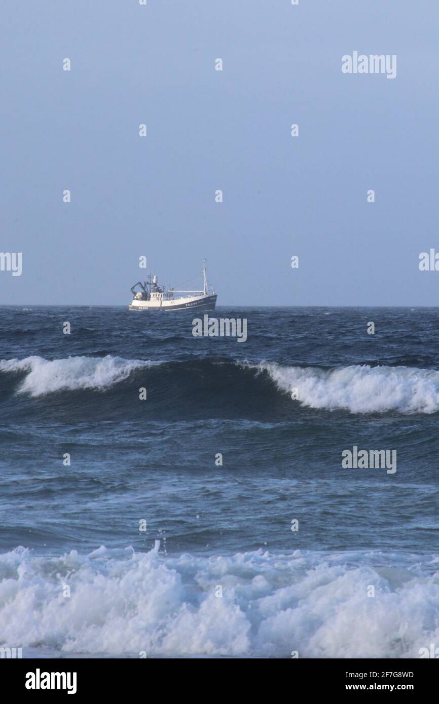 Fishing boat on horizon Stock Photo - Alamy