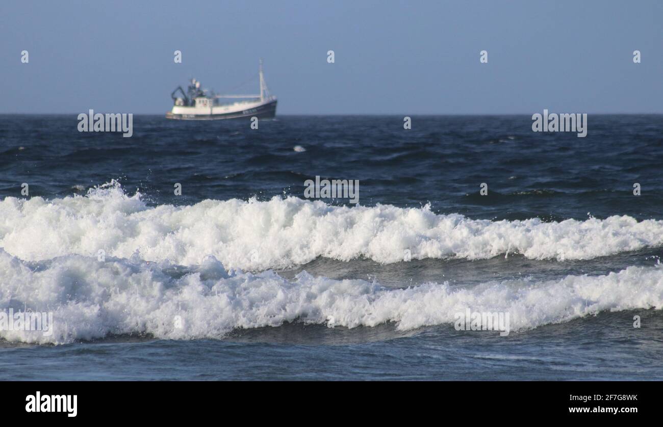 Fishing boat on horizon Stock Photo - Alamy
