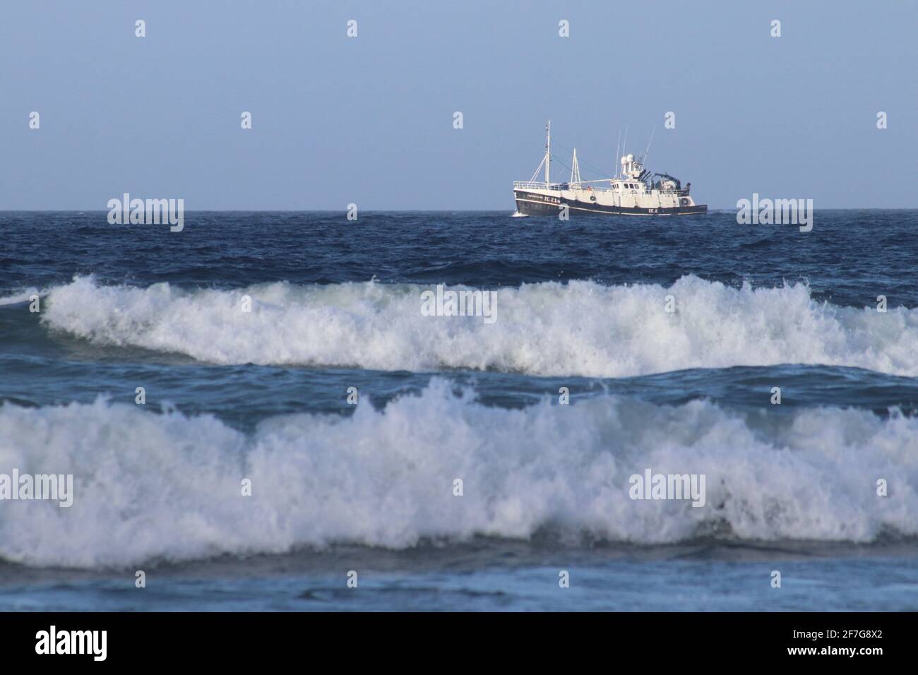 Fishing boat on horizon Stock Photo - Alamy