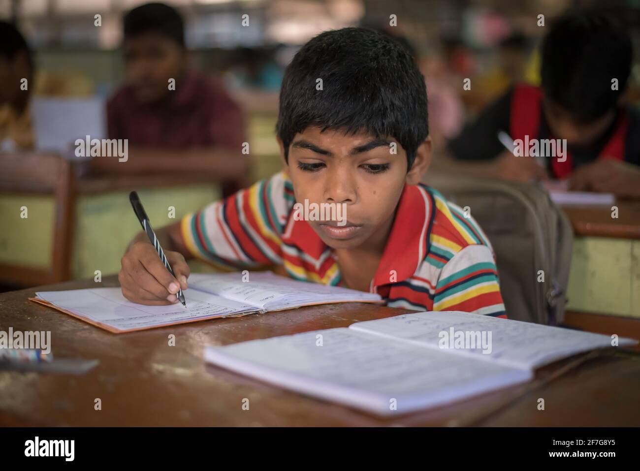 Varanasi, India. 10-16-2019. Portrait of a boy doing writing in his ...