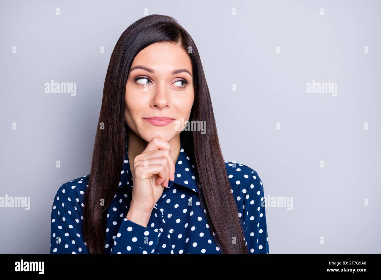 Portrait of optimistic brunette girl look empty space hand chin wear ...